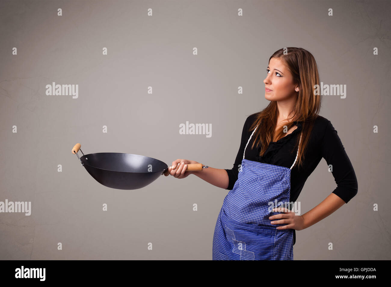Young lady holding a frying pan Stock Photo - Alamy