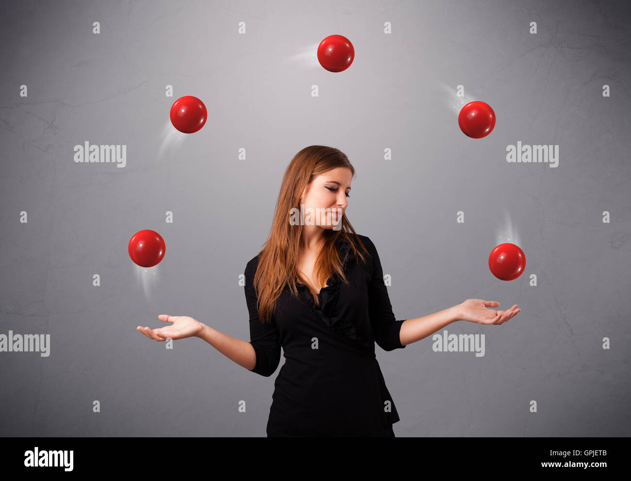 young girl standing and juggling with red balls Stock Photo - Alamy