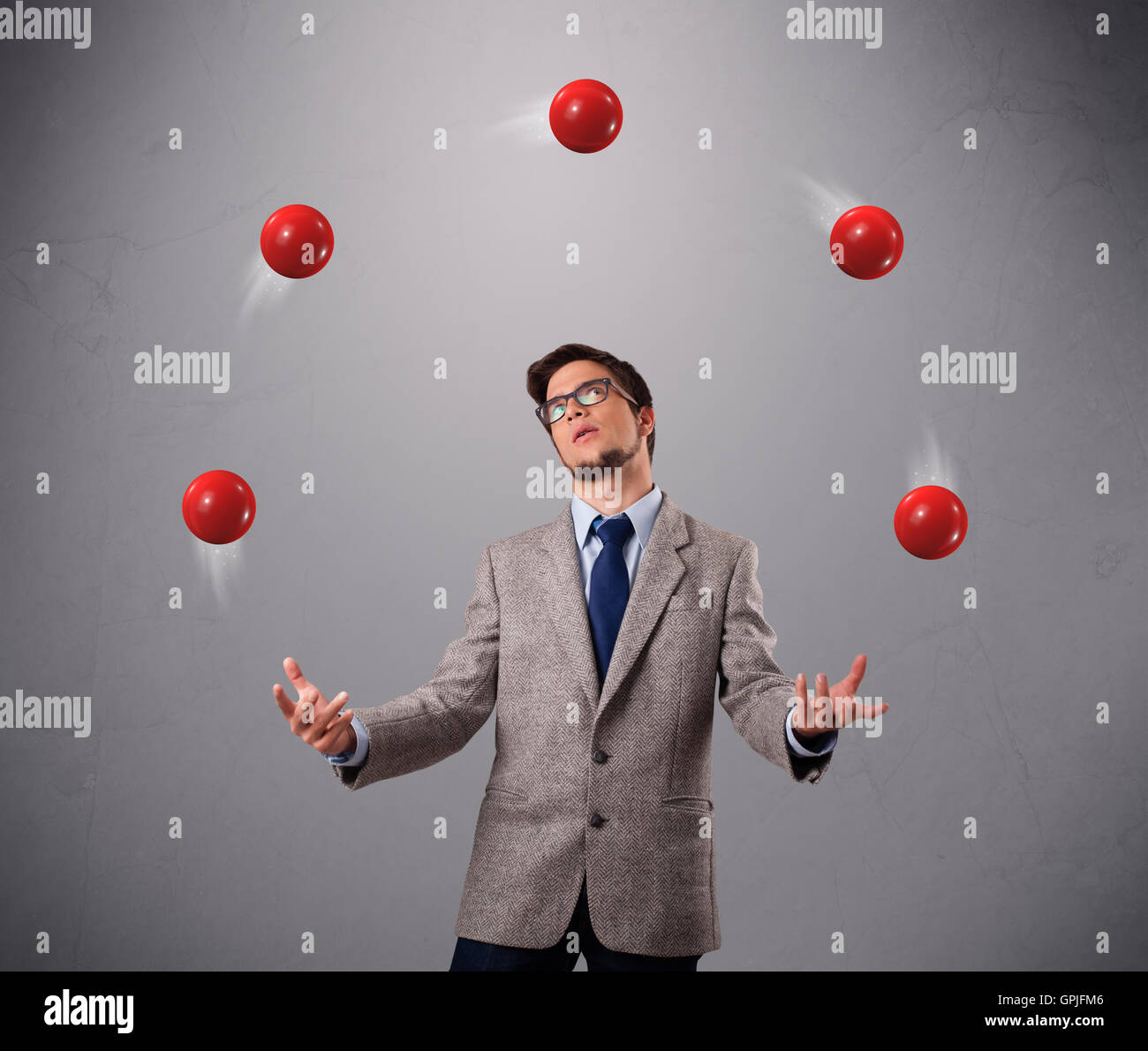young man standing and juggling with red balls Stock Photo - Alamy