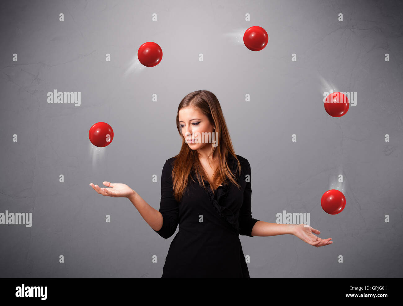 young girl standing and juggling with red balls Stock Photo - Alamy