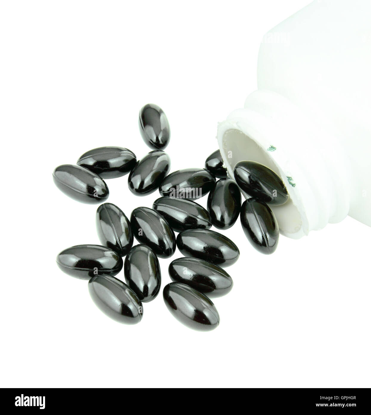 black pills an pill bottle on white Stock Photo - Alamy