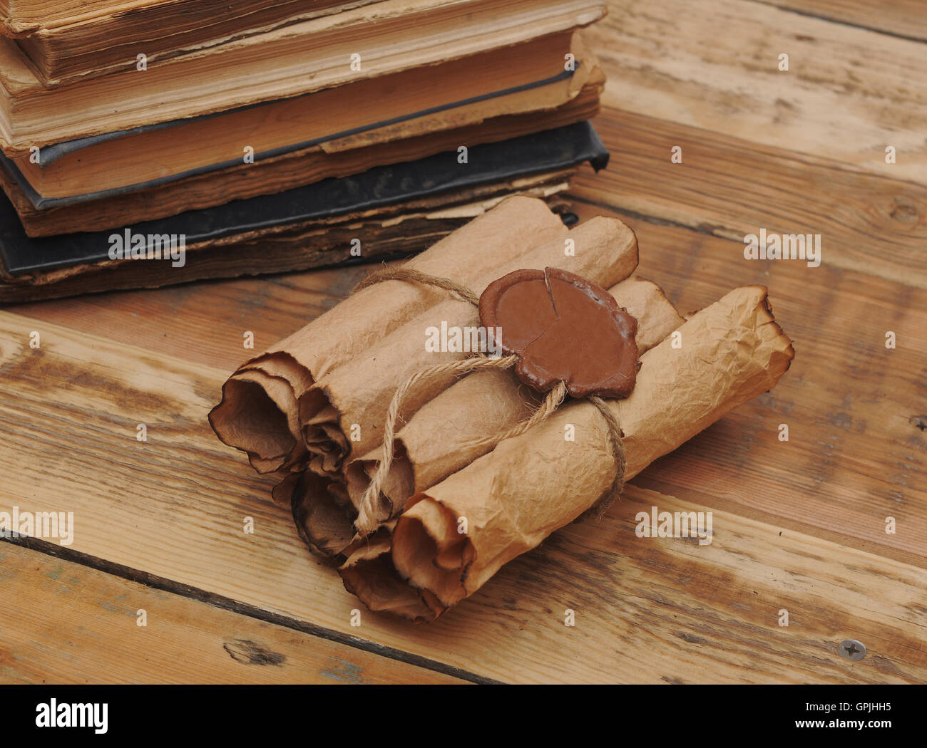 Pile of old books and scroll on wood background Stock Photo - Alamy