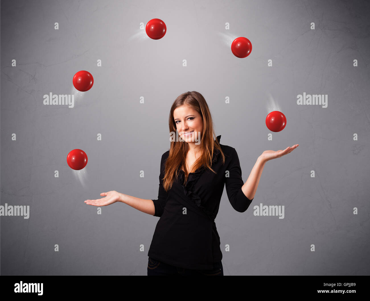 young girl standing and juggling with red balls Stock Photo - Alamy