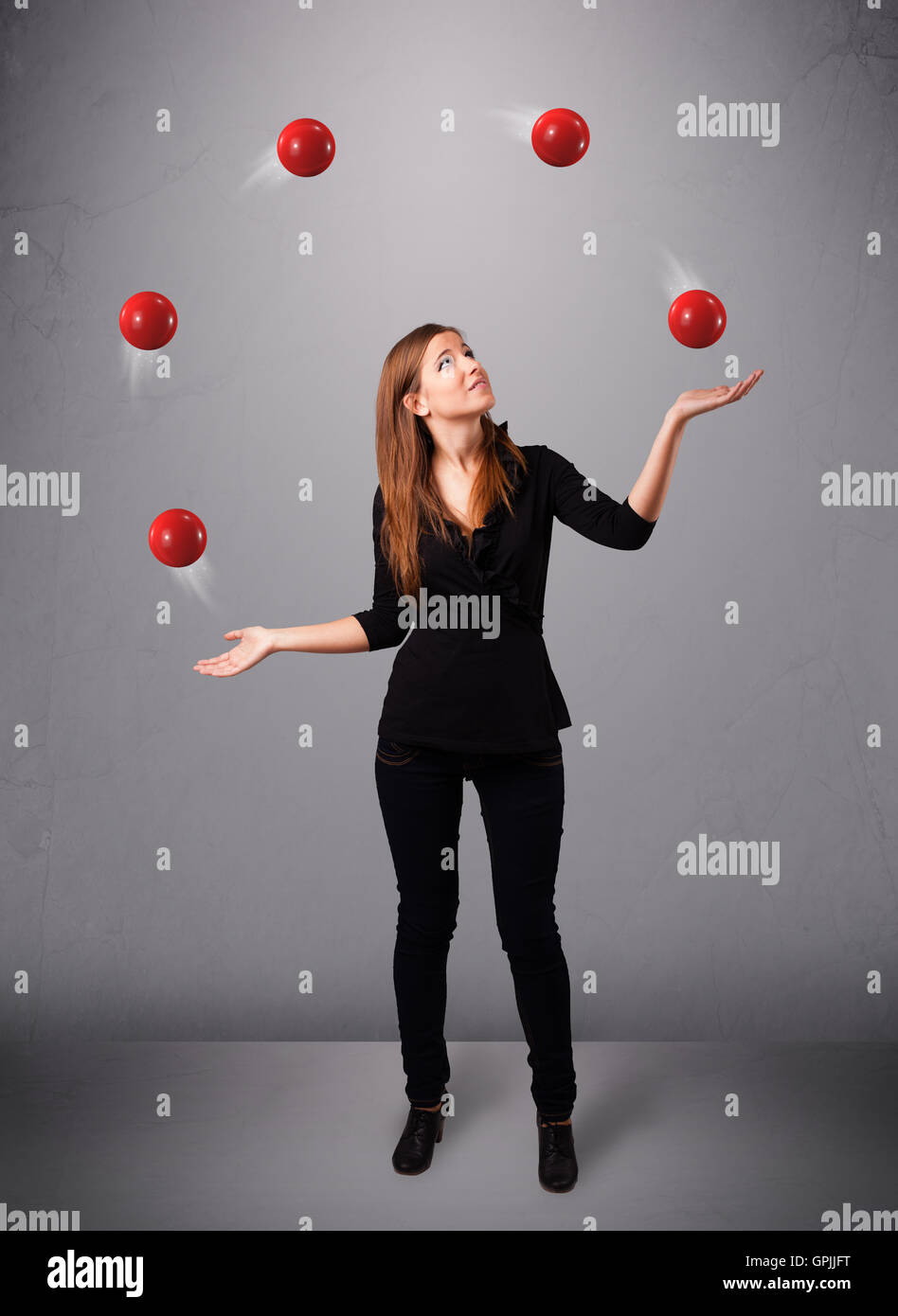 young girl standing and juggling with red balls Stock Photo - Alamy
