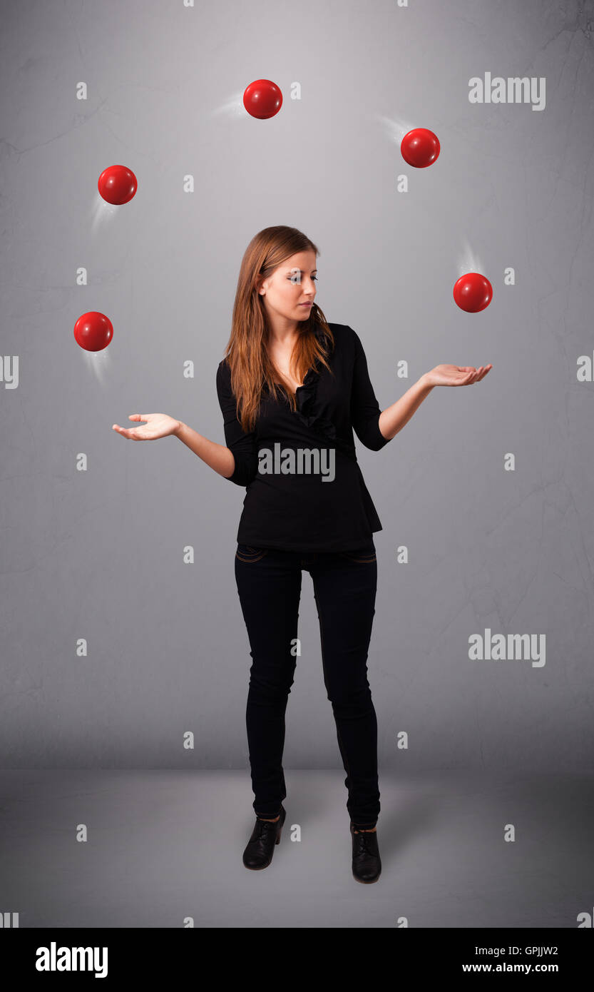 young girl standing and juggling with red balls Stock Photo - Alamy