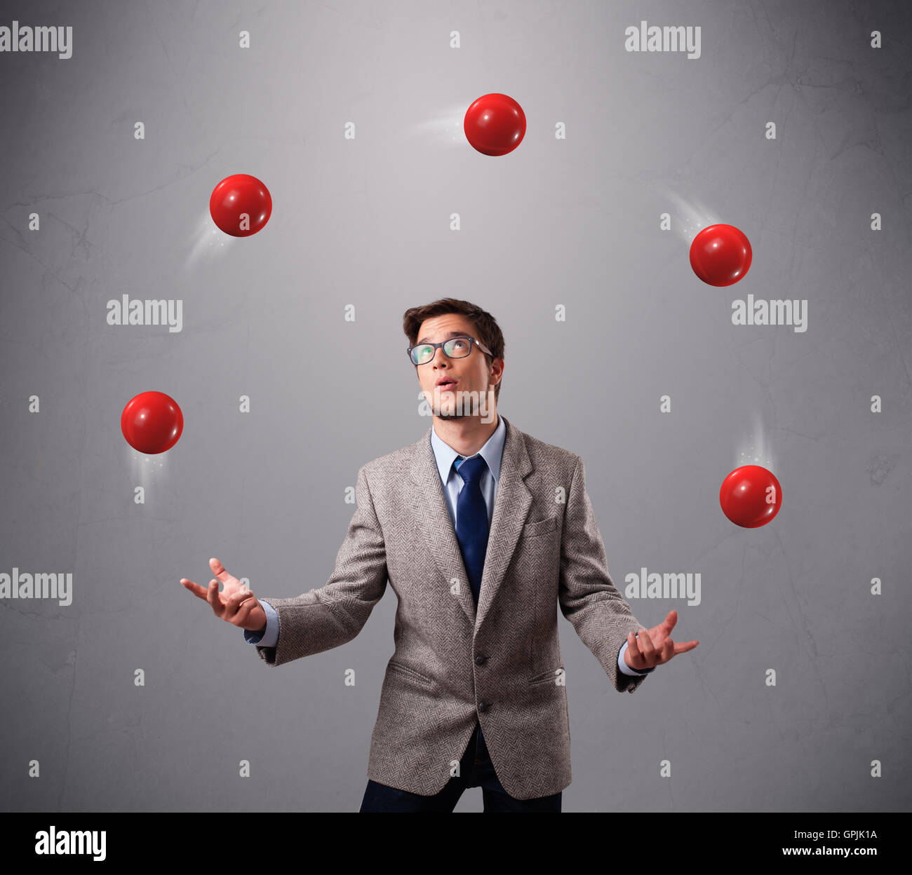 young man standing and juggling with red balls Stock Photo - Alamy