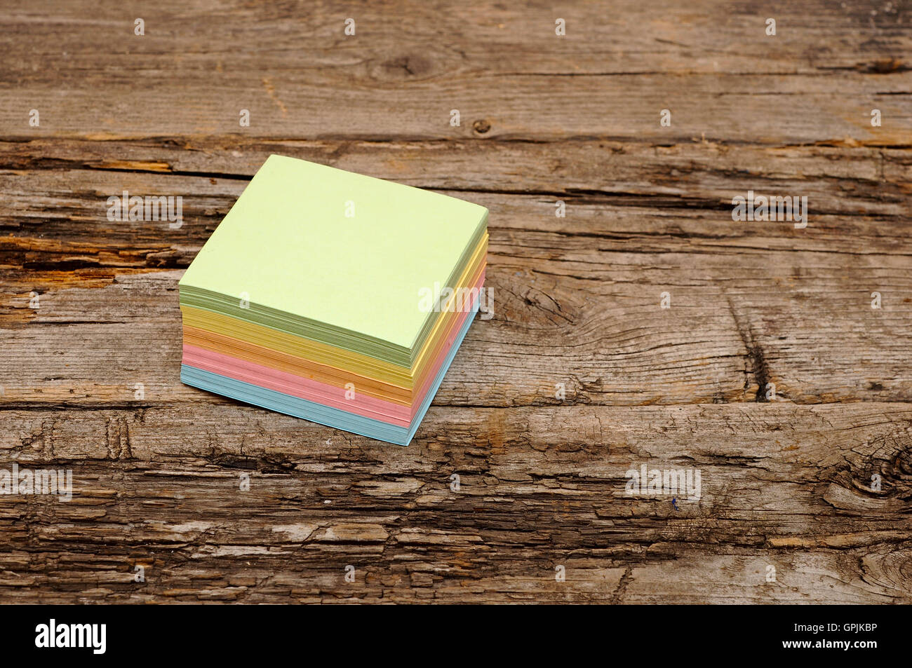 Vibrant block of colorful post it notes on wooden background Stock ...
