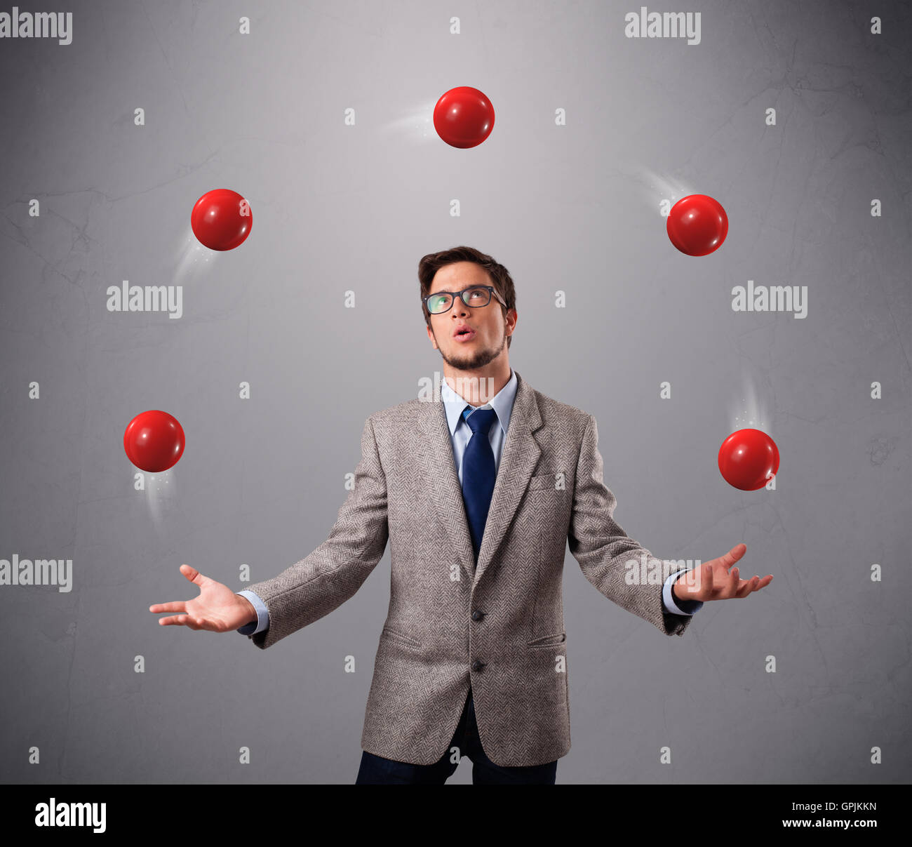 young man standing and juggling with red balls Stock Photo - Alamy
