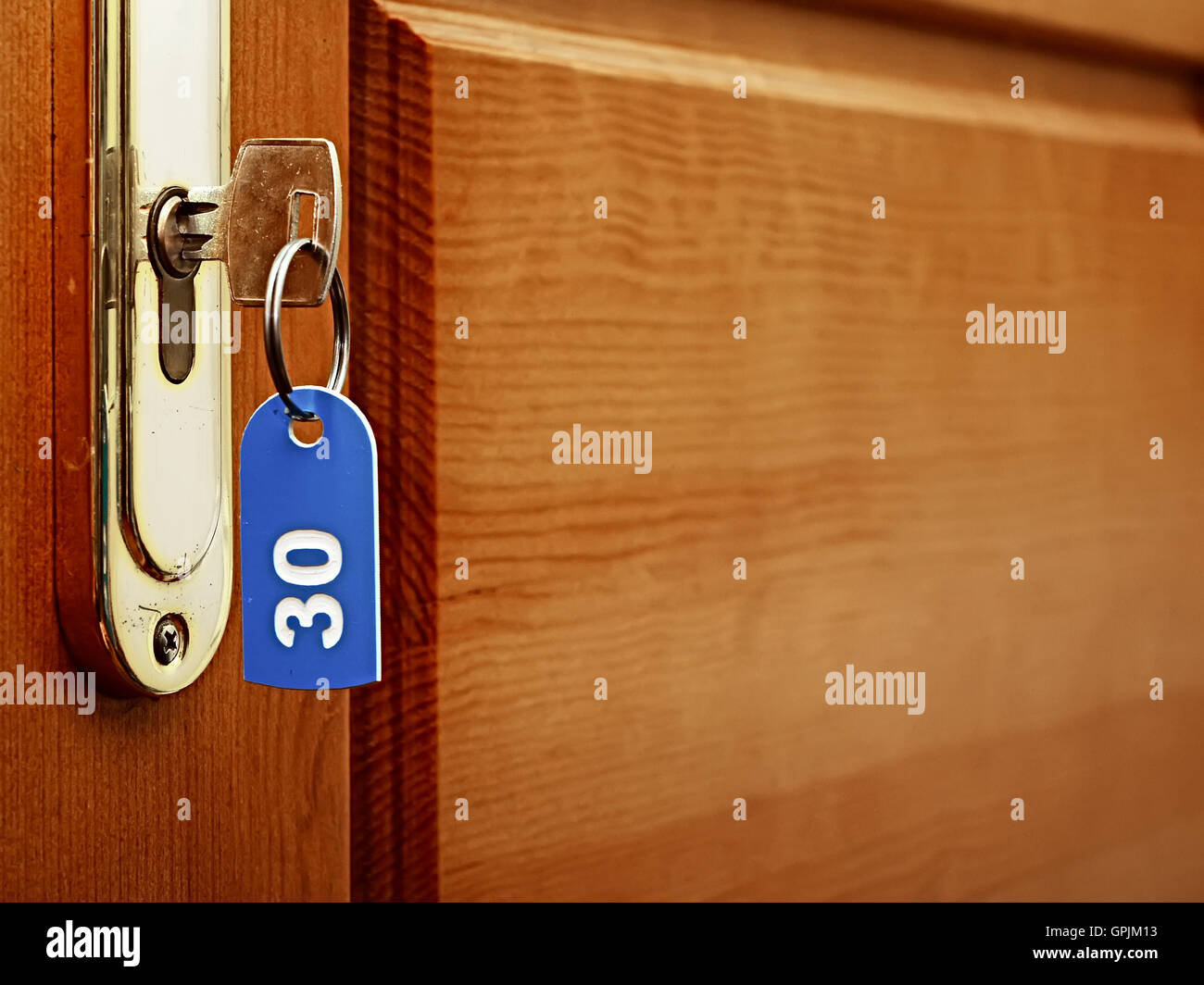 Door wood and key in keyhole with numbered label Stock Photo - Alamy