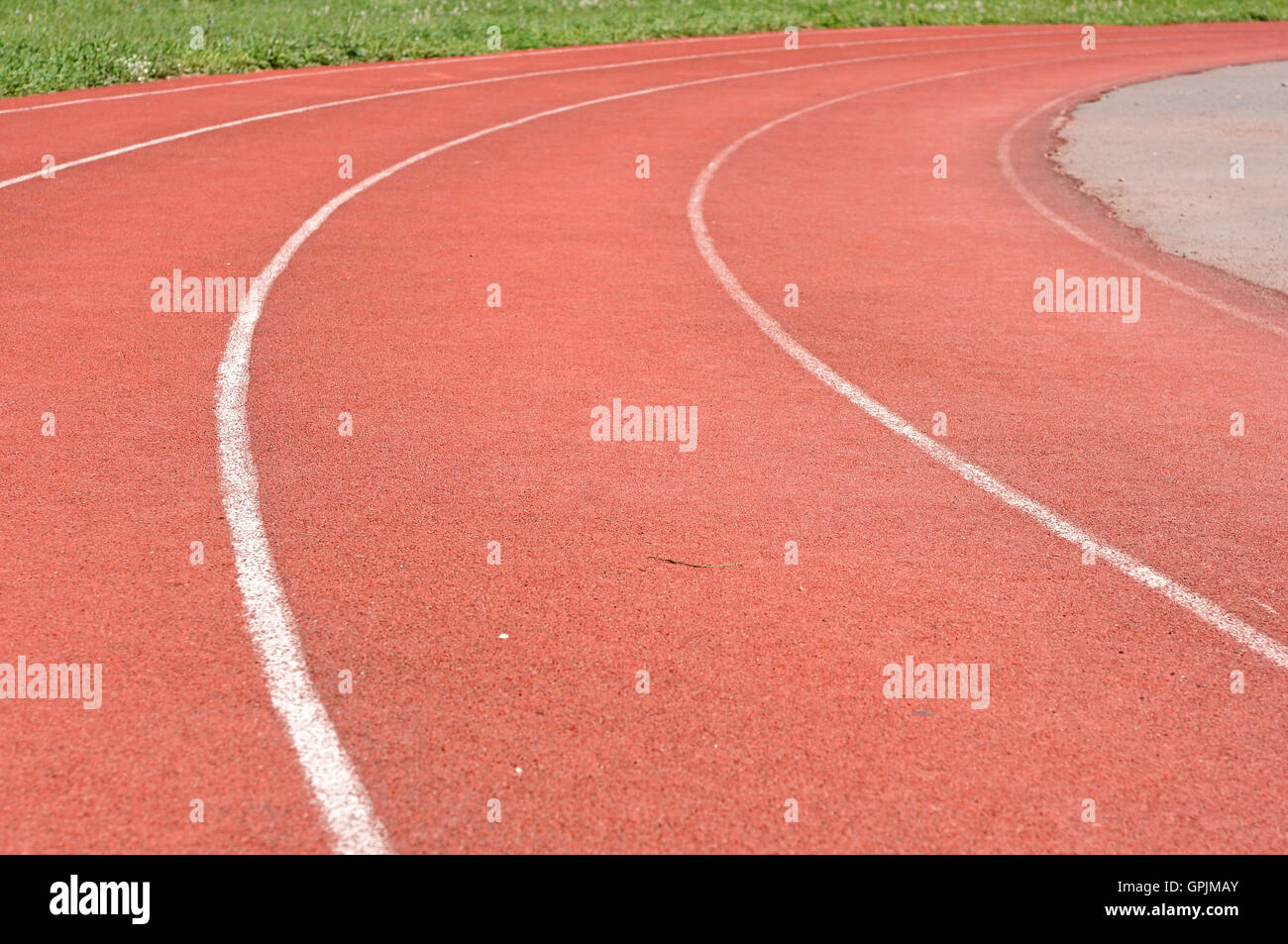 Curve on a red running track in arena Stock Photo - Alamy