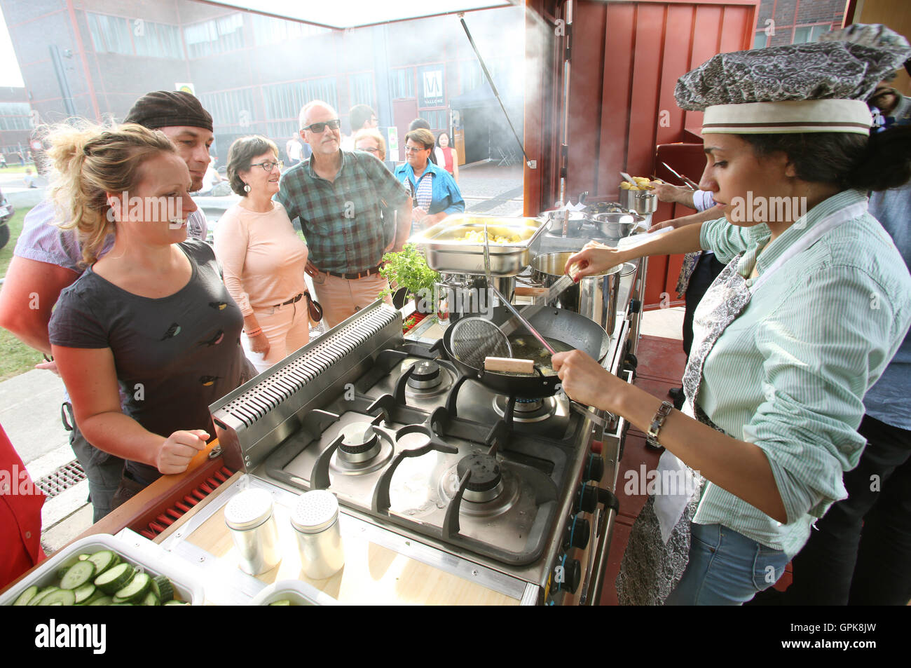 People standing at the Refugees Kitchen and waiting for the food in ...