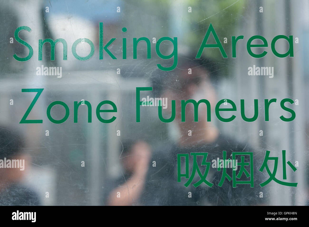 A man smokes in a designated smoking area outside Shibuya station on ...