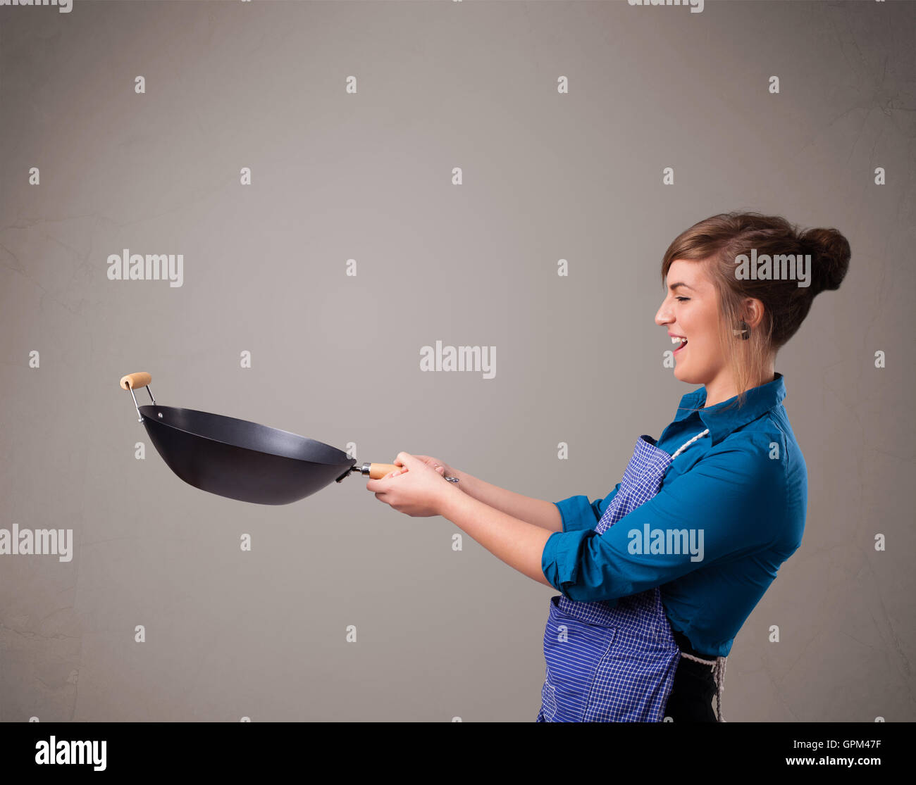 Young lady holding a frying pan Stock Photo - Alamy