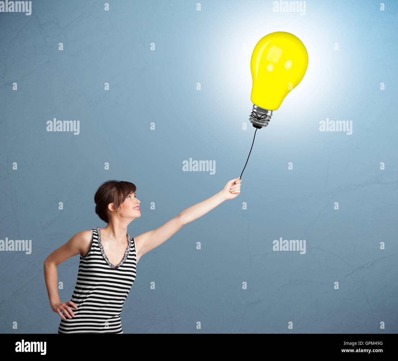 Pretty lady holding a light bulb balloon Stock Photo - Alamy