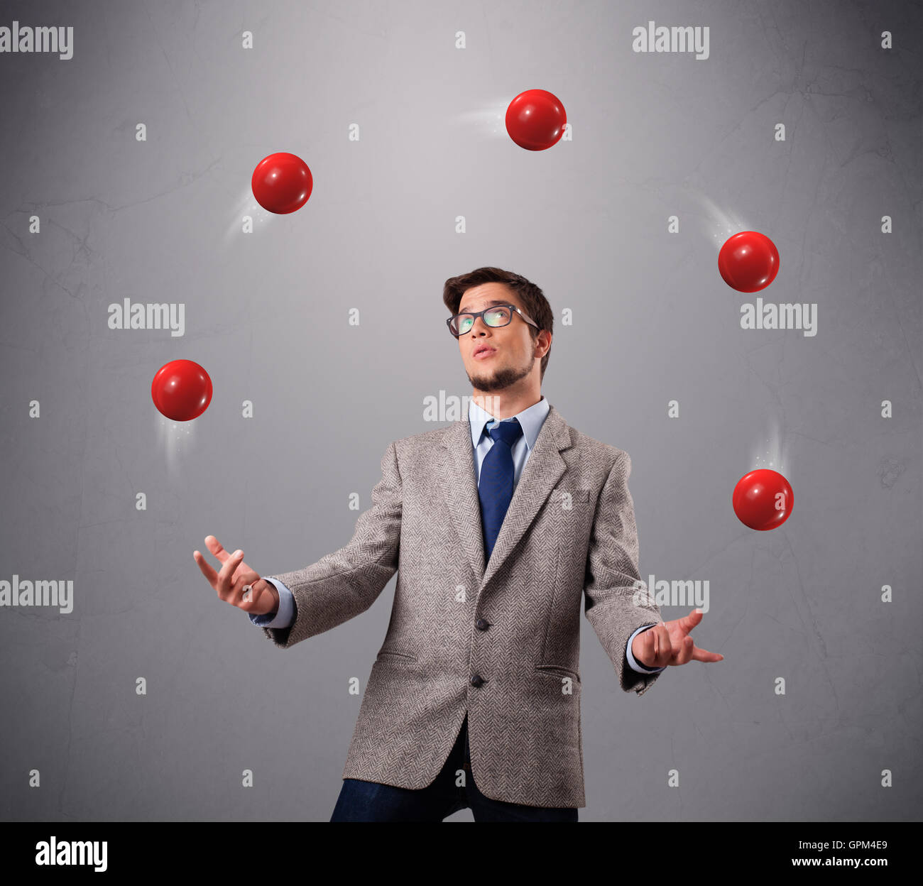 young man standing and juggling with red balls Stock Photo - Alamy
