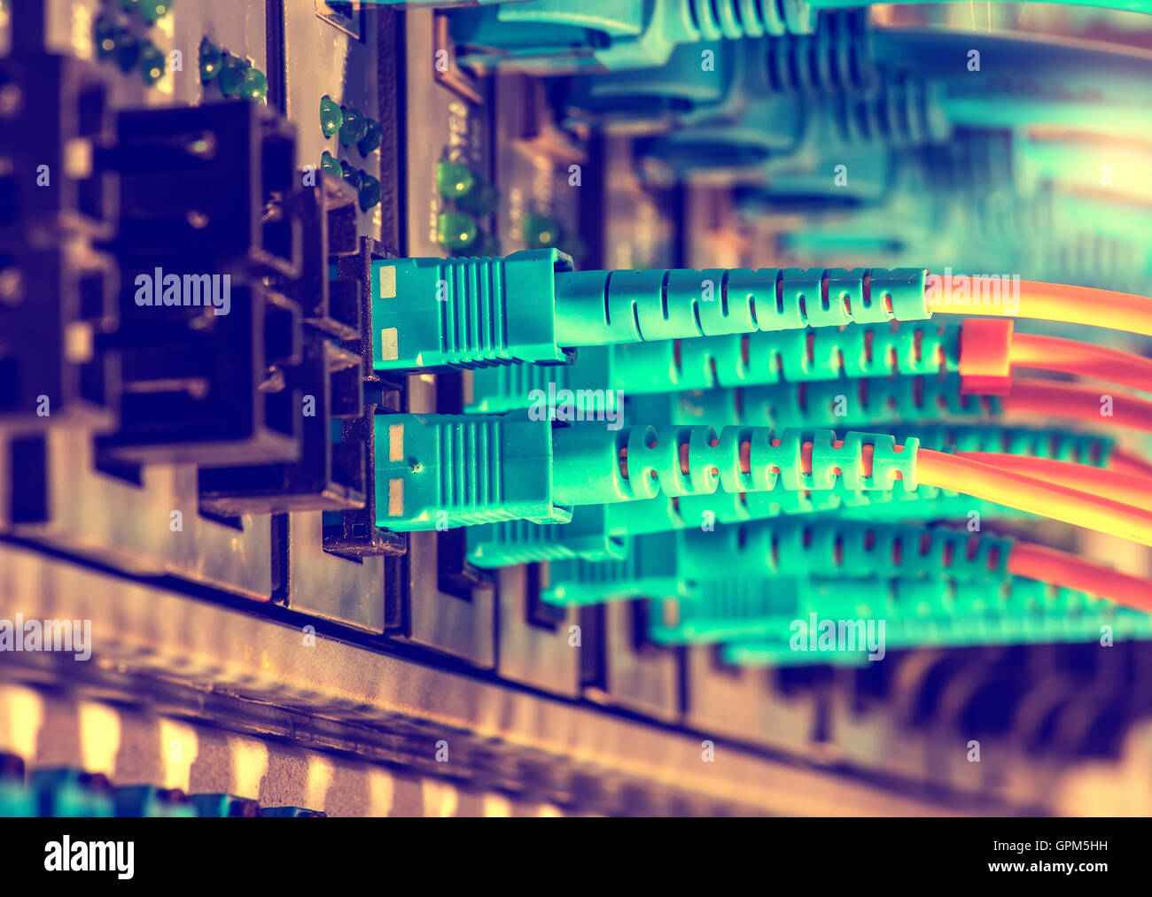 Fiber Optic cables connected to an optic ports and Network cables ...