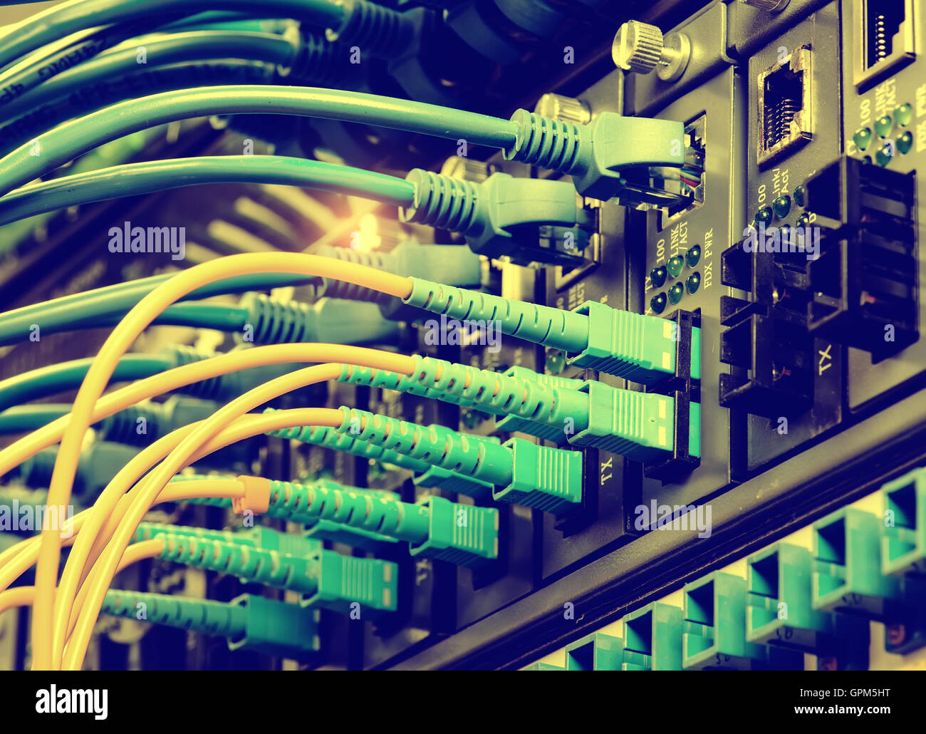 Fiber Optic cables connected to an optic ports and Network cables ...