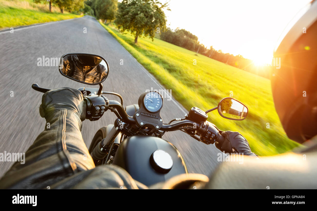 Motorcycle driver riding on motorway in beautiful sunset light. Shot ...