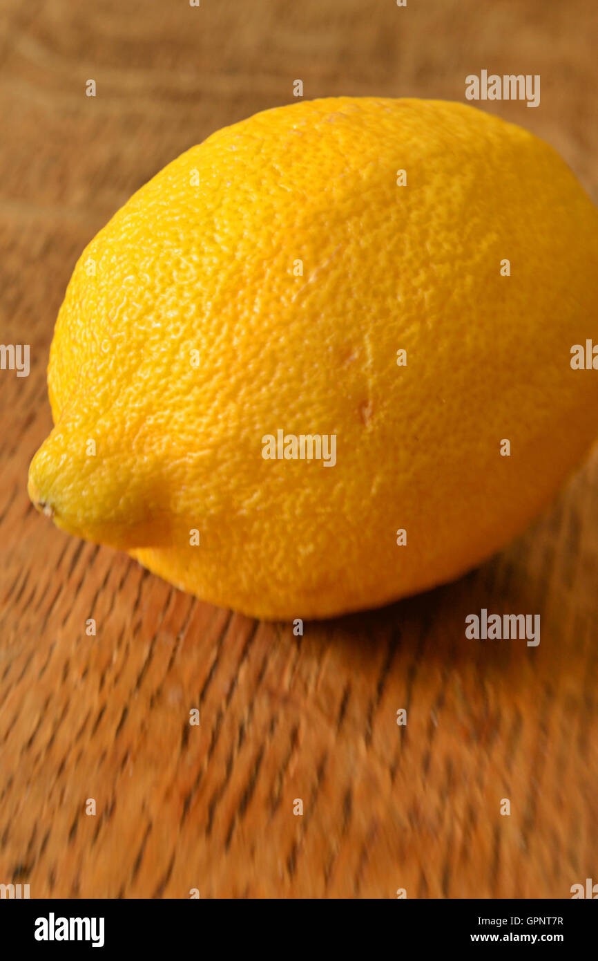 Single lemon lying on dark wood table. Shot with LensBaby for selective ...