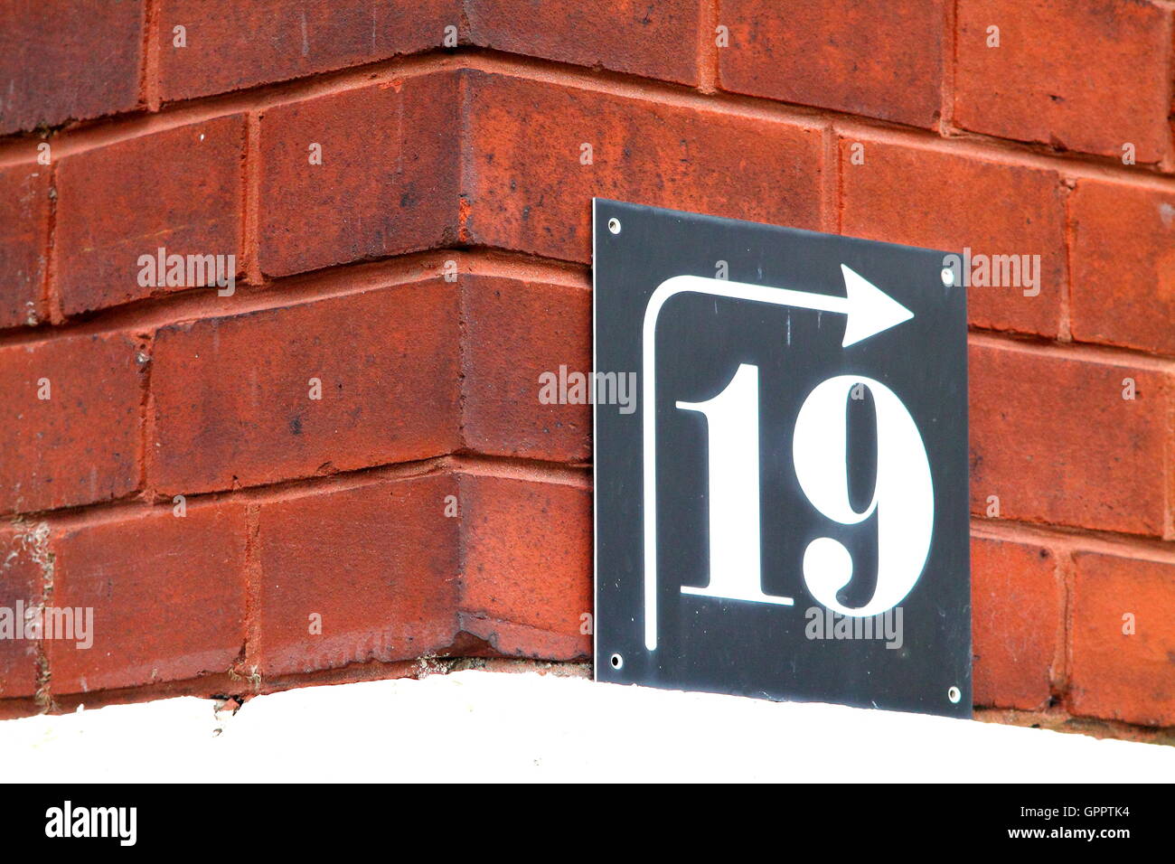 House number nineteen with arrow Stock Photo - Alamy