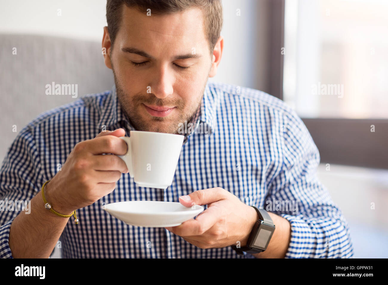 Delighted man drinking coffee Stock Photo - Alamy