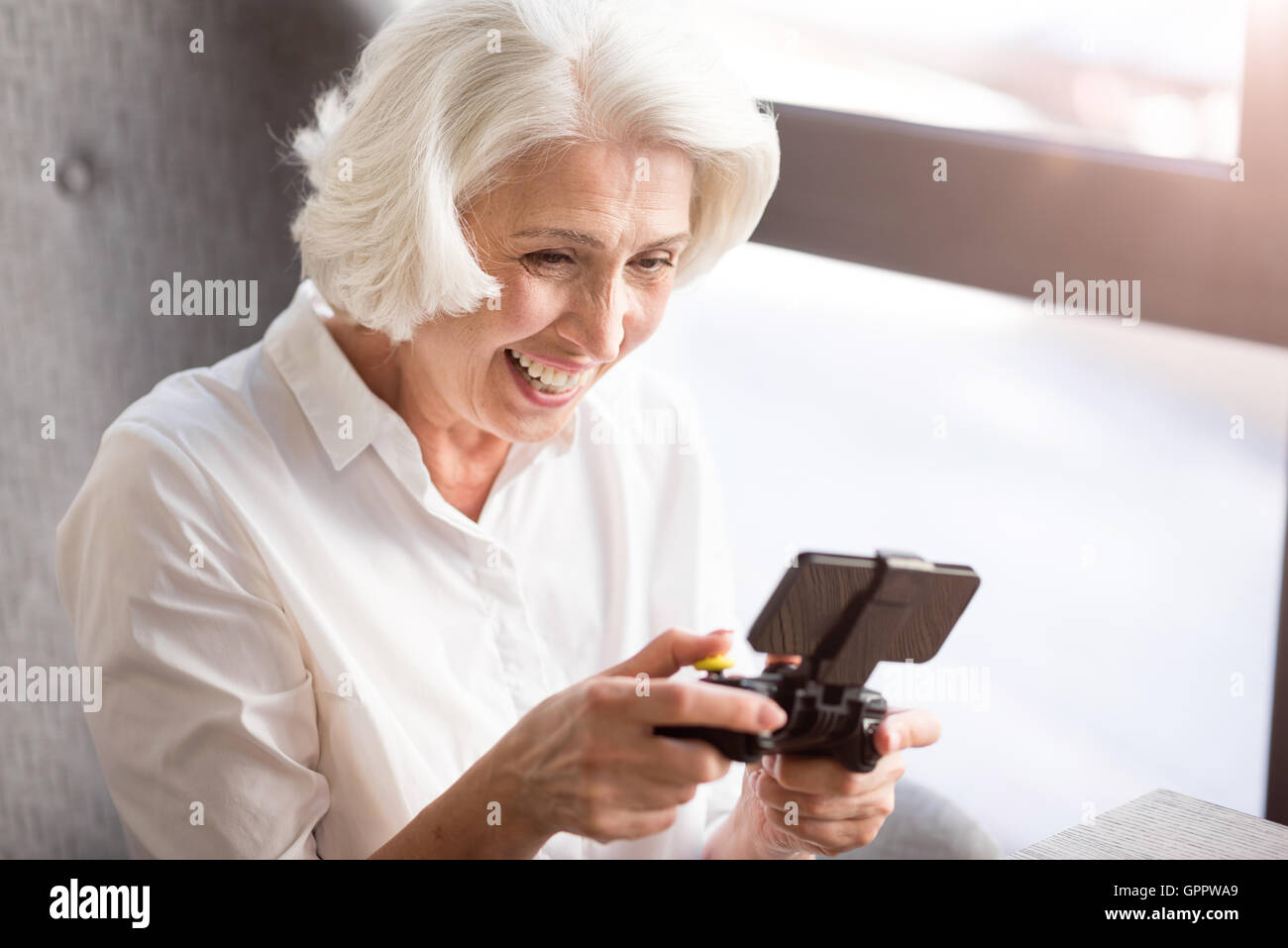Senior woman playing video games hi-res stock photography and images ...