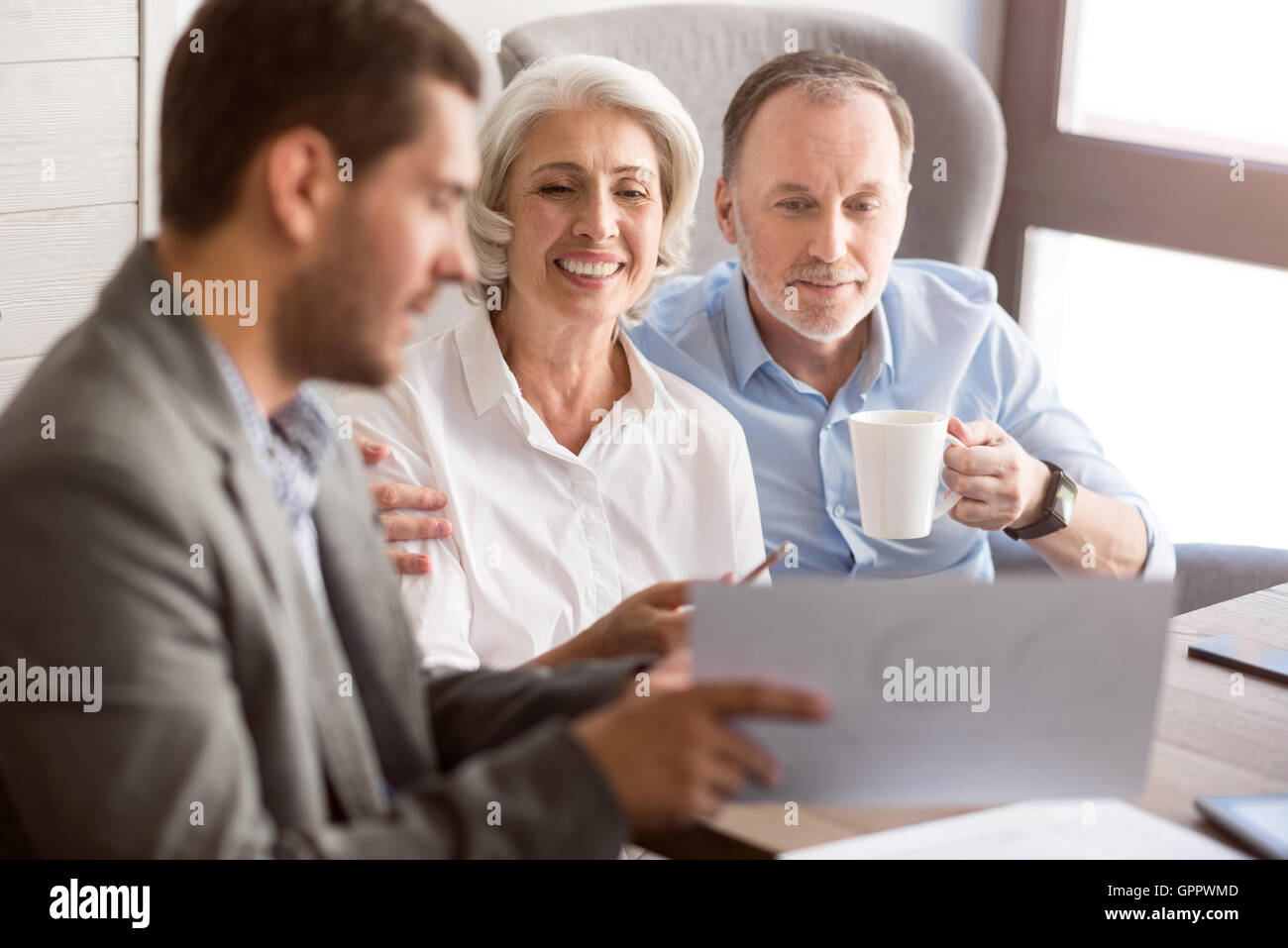 Cheerful couple talking with sales manager Stock Photo - Alamy