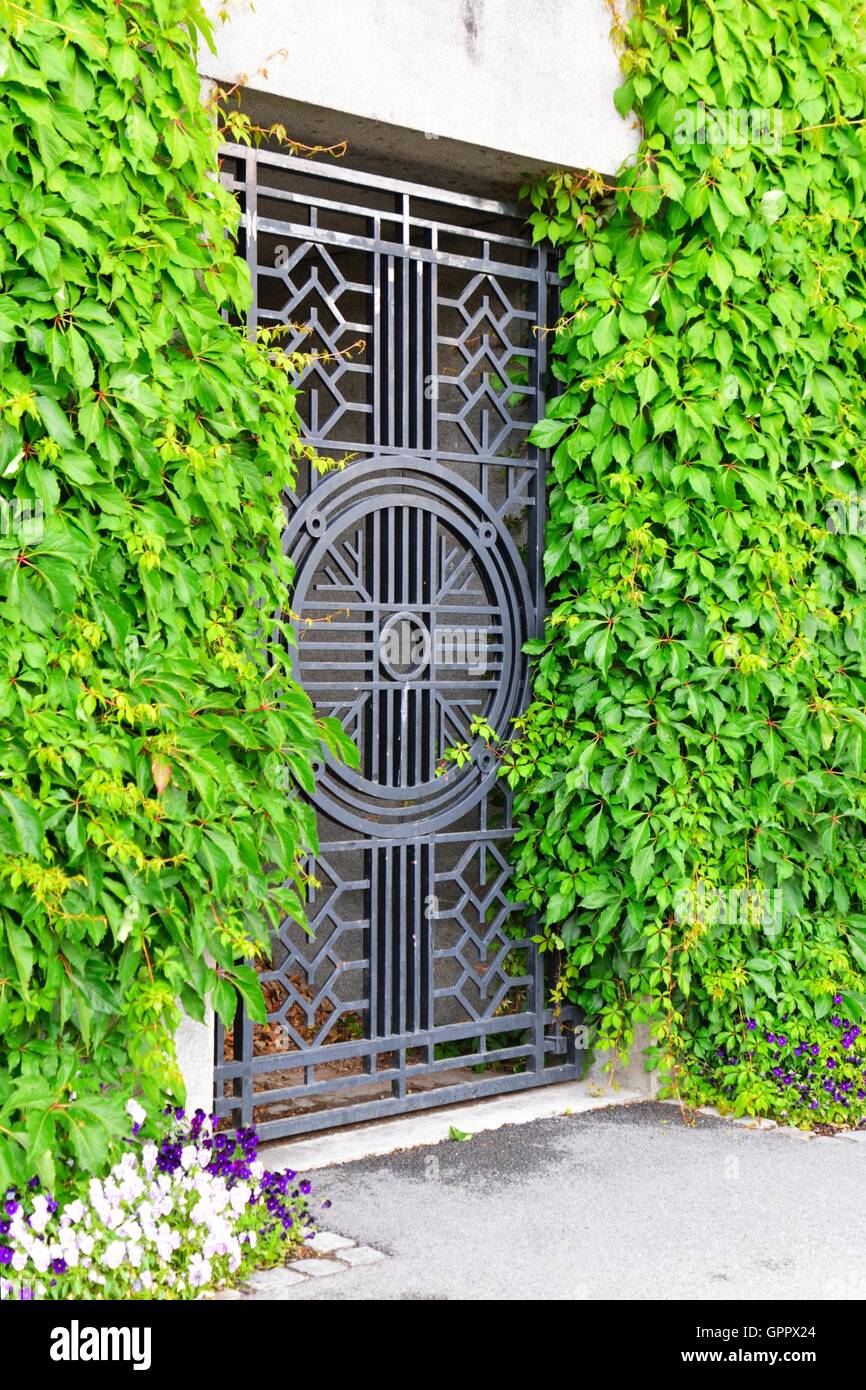 Old iron gate and overgrown plants Stock Photo - Alamy