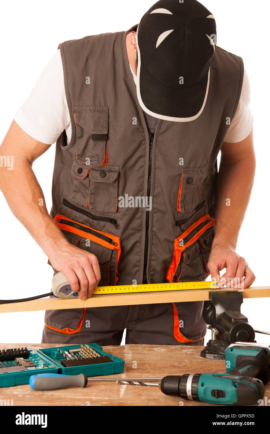 A carpenter measuring a wooden plank in a workshop isolated over white ...