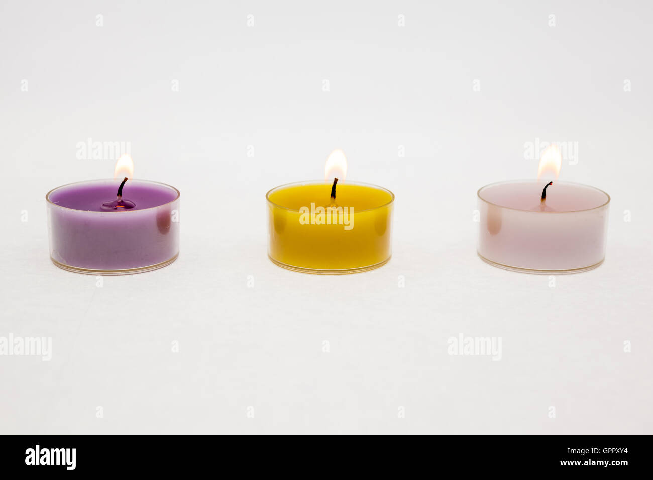 different colors of tea light candles with white background Stock Photo ...