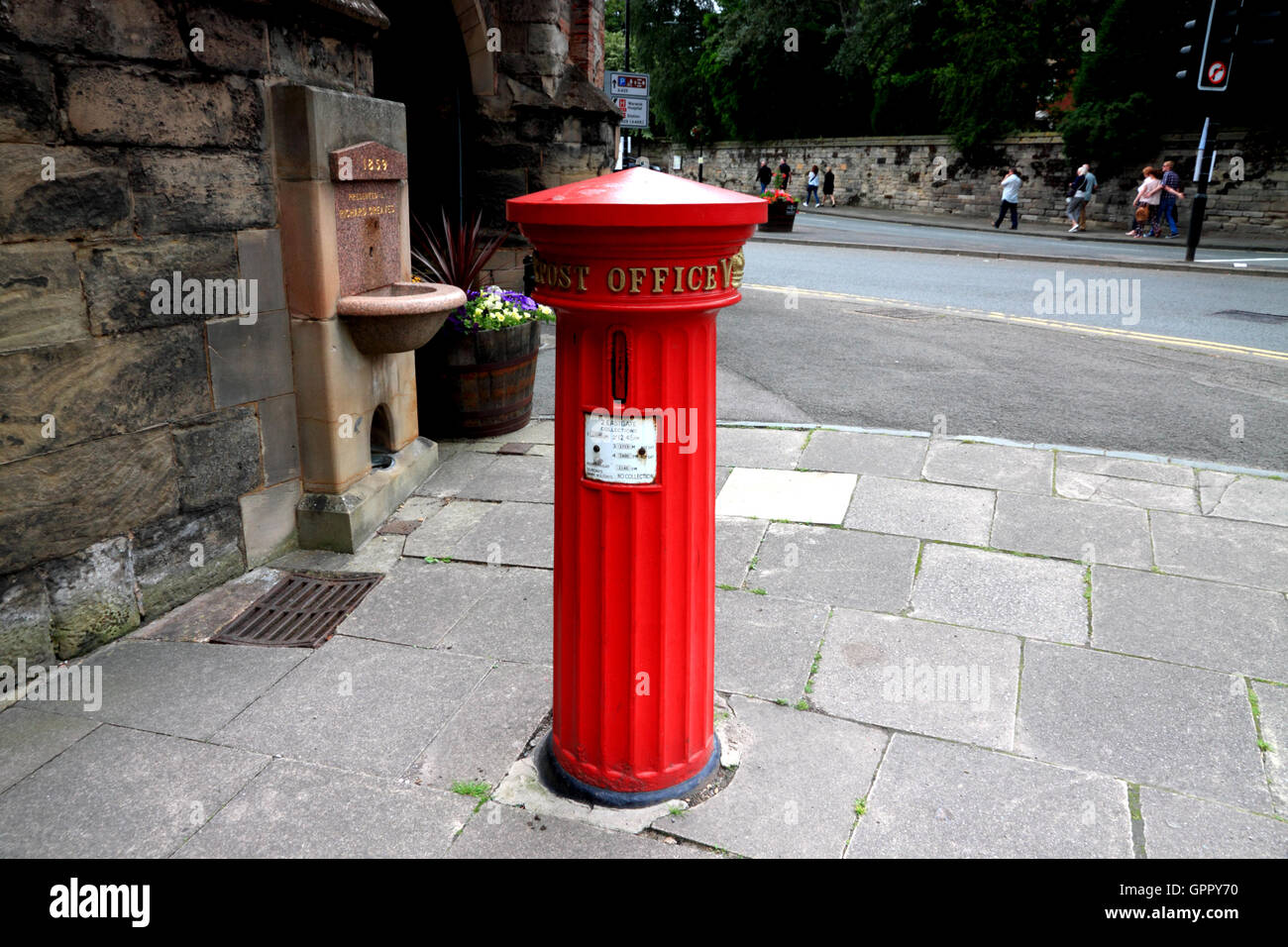 Doric style red Victorian pillar box with vertical aperture in a street ...
