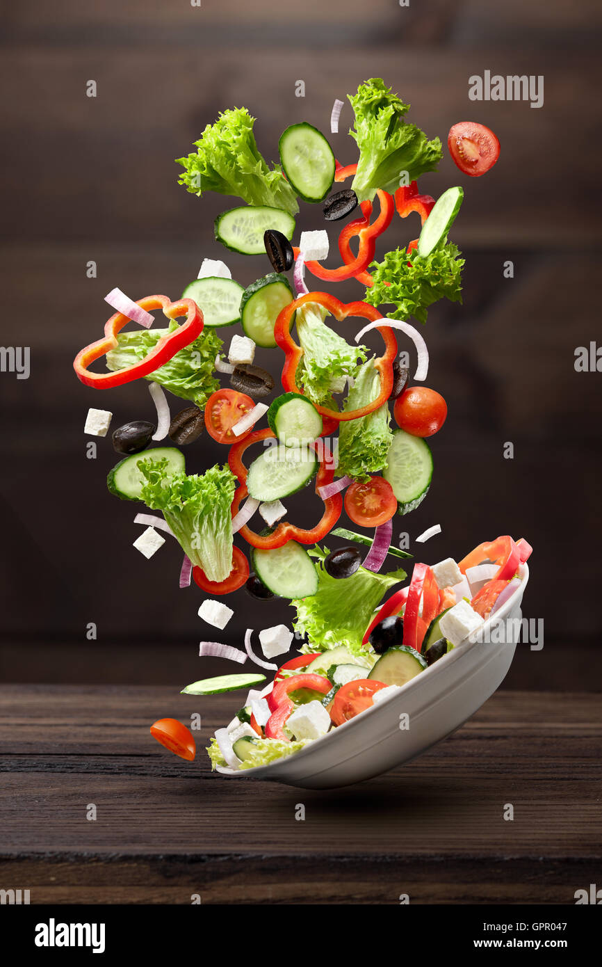 flying salad on wooden background Stock Photo - Alamy