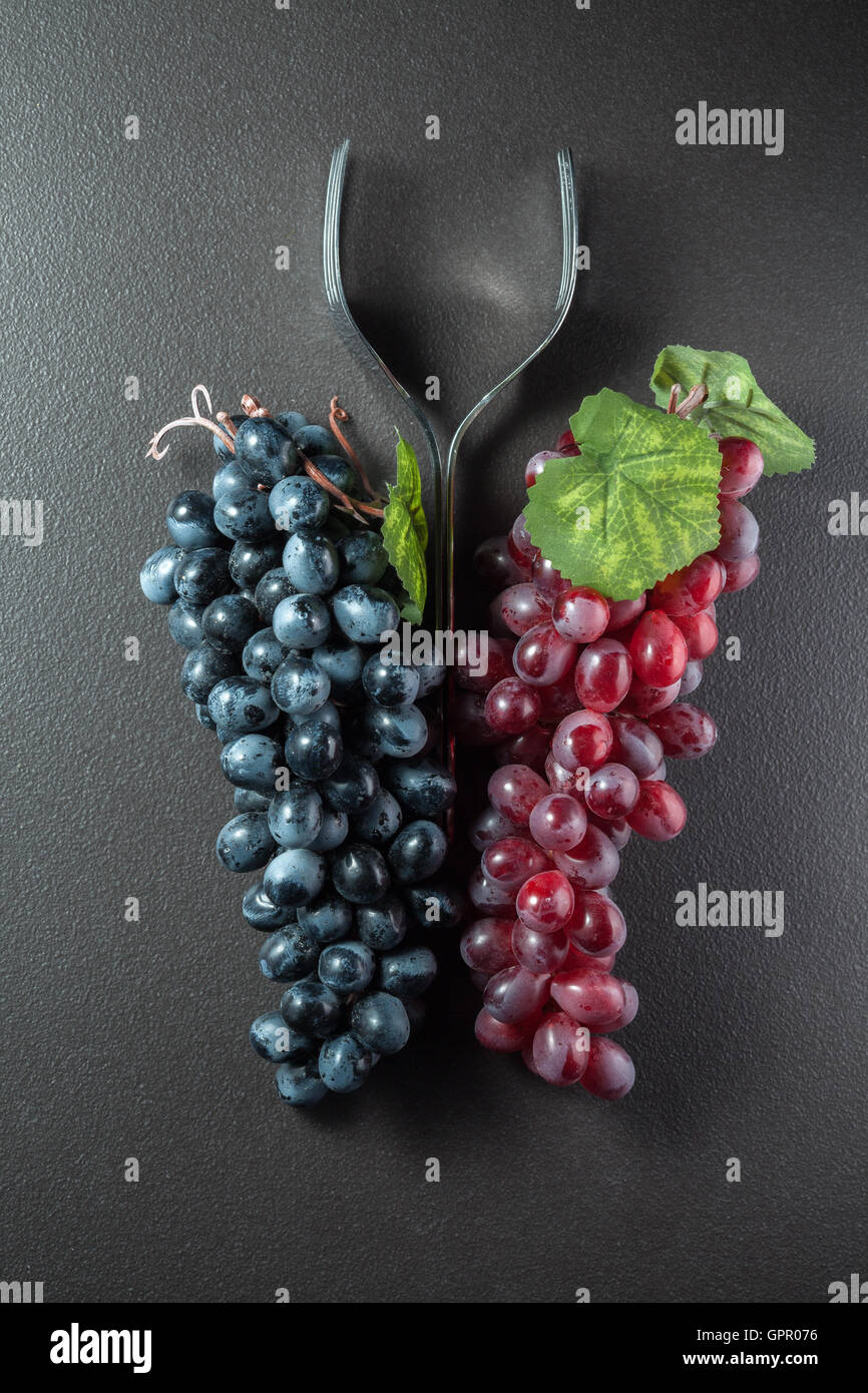 Wine glass made of forks and grape on black Stock Photo - Alamy
