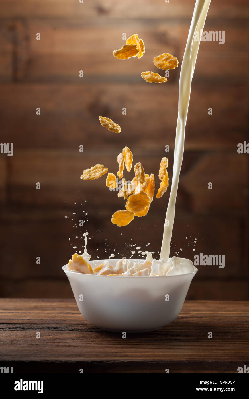 Falling corn flakes with milk splash on wood Stock Photo - Alamy