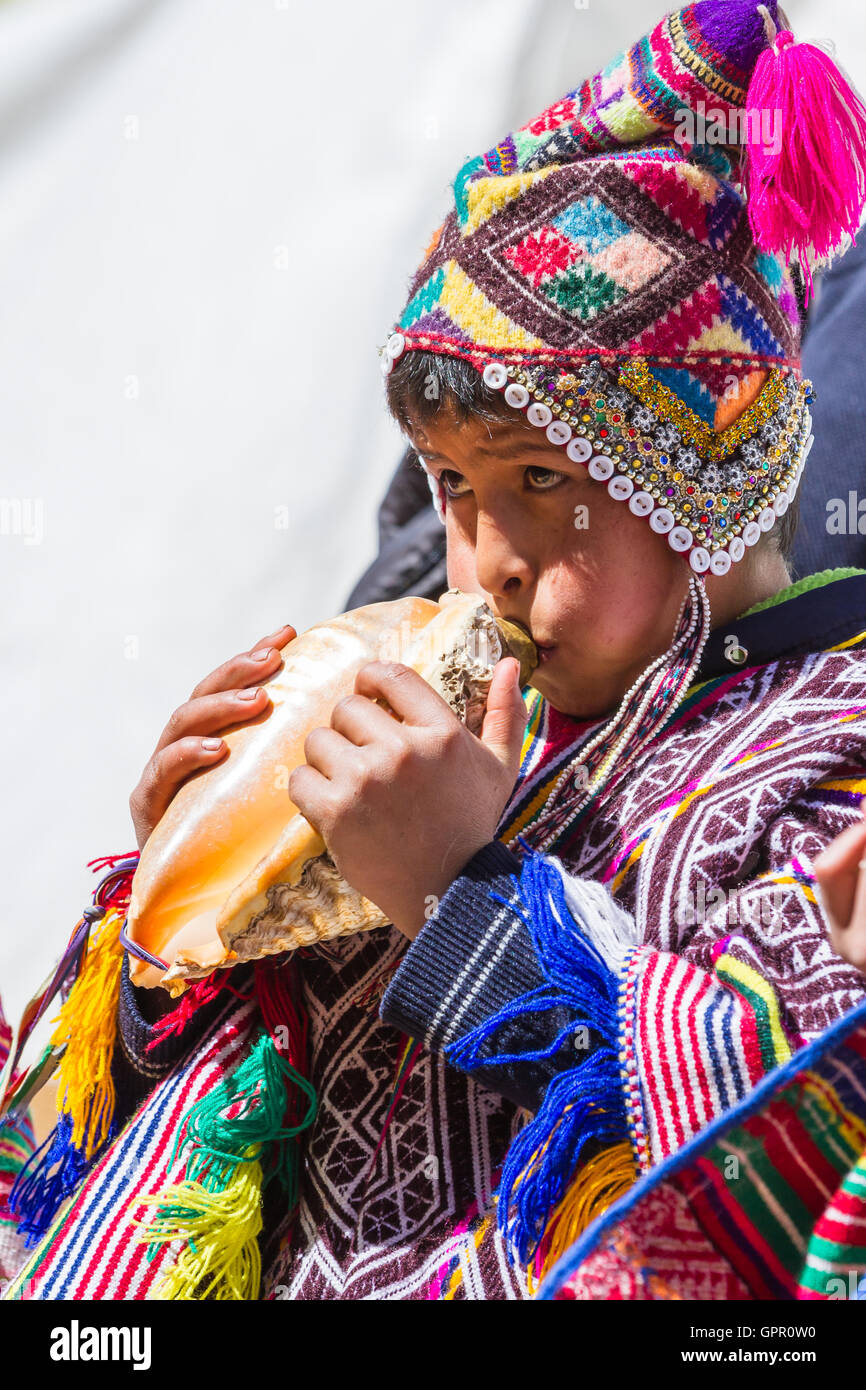 Pisac, Peru - May 15: Young man playing a tune using a conch shell as ...