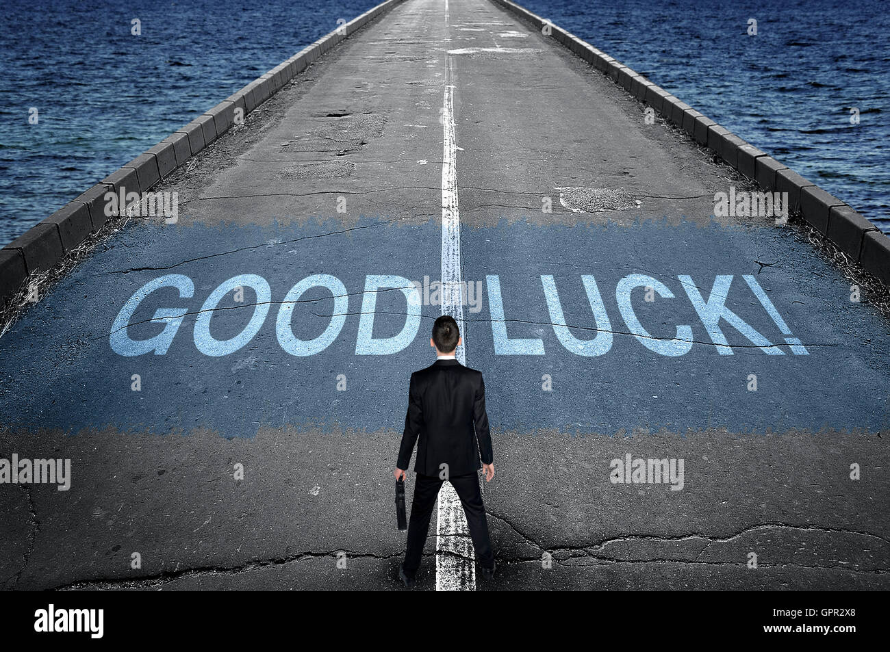 Good luck message on road and business man Stock Photo - Alamy