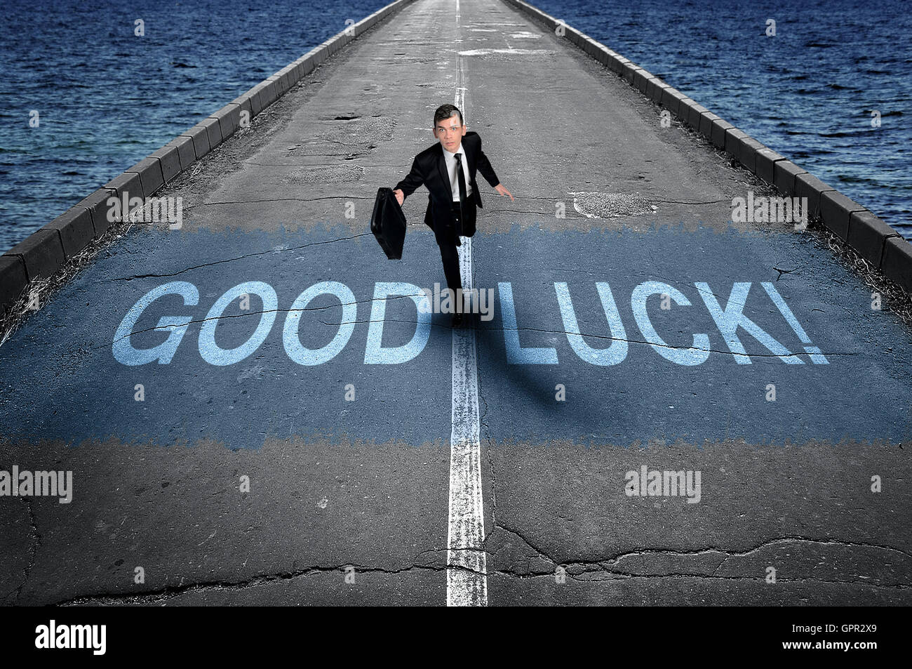Good luck message on road and business man Stock Photo - Alamy