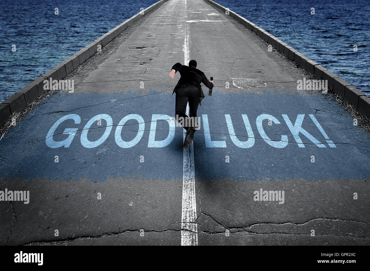Good luck message on road and business man Stock Photo - Alamy