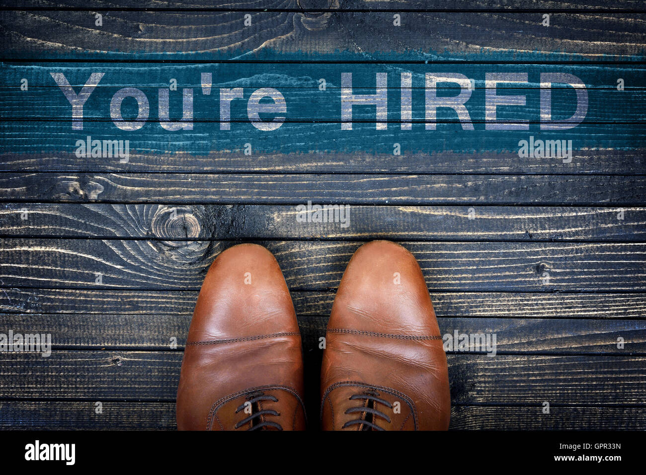 You're hired message and business shoes on wooden floor Stock Photo - Alamy