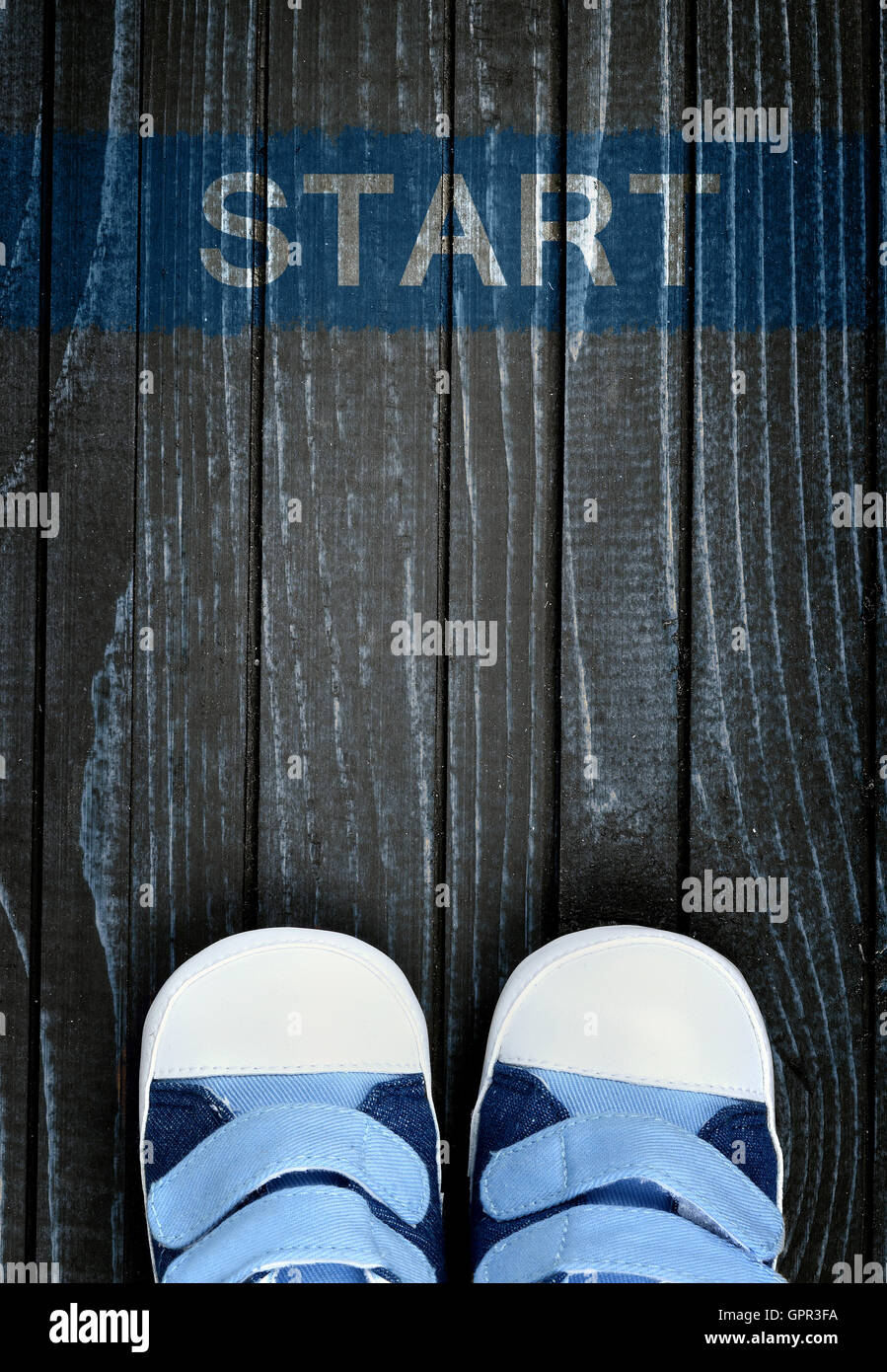 Start message and kid shoes on wooden floor Stock Photo - Alamy