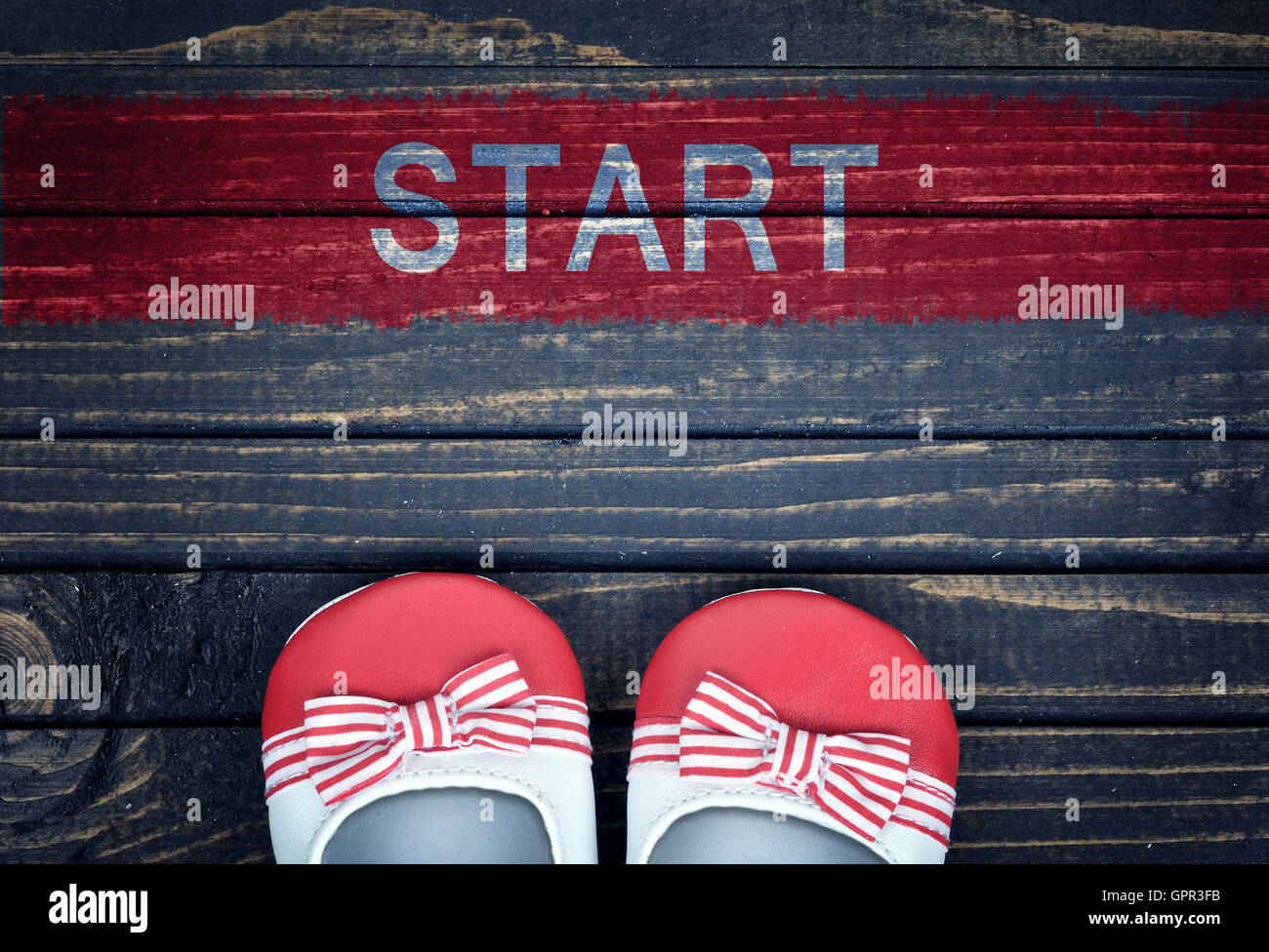 Start message and kid shoes on wooden floor Stock Photo - Alamy