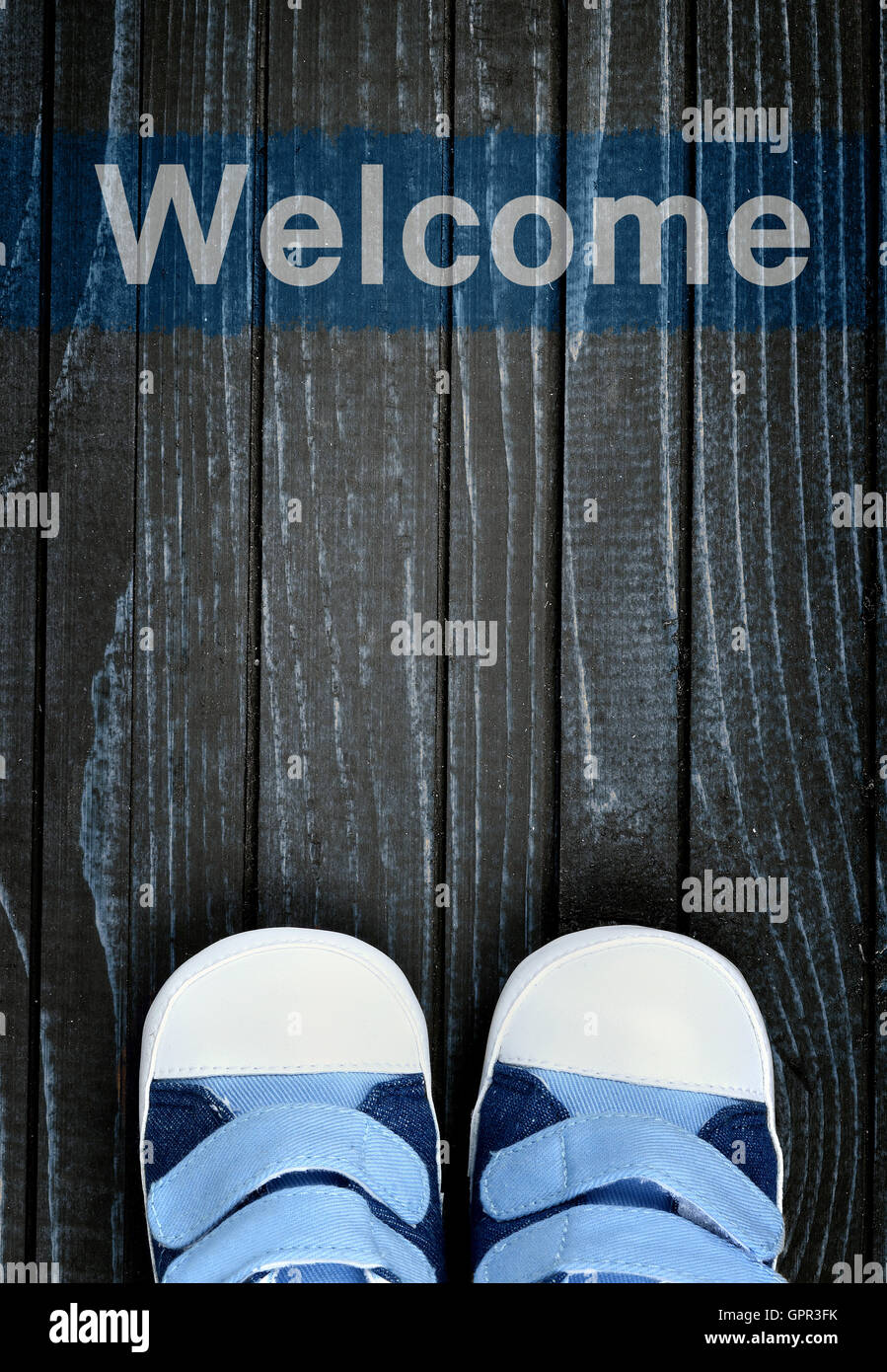 Welcome message and kid shoes on wooden floor Stock Photo - Alamy