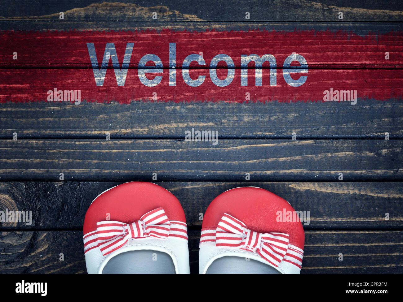 Welcome message and kid shoes on wooden floor Stock Photo - Alamy