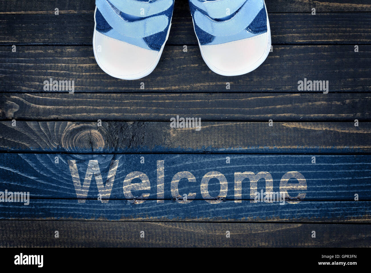 Welcome message and kid shoes on wooden floor Stock Photo - Alamy