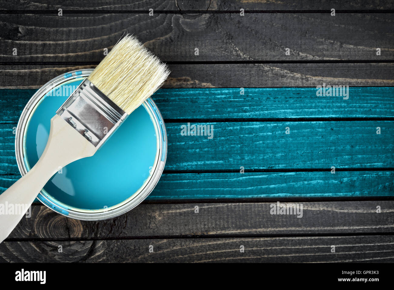 Paint bucket and brush on wooden table Stock Photo - Alamy