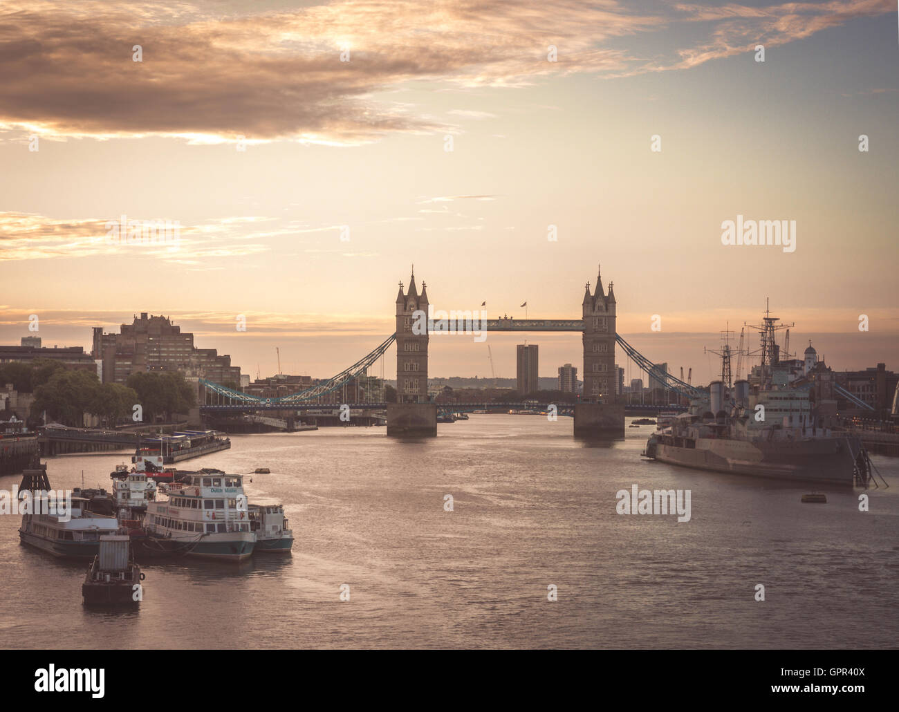 The beautiful sunrise behind the Tower Bridge and the HMS Belfast warship, London, England, UK ...