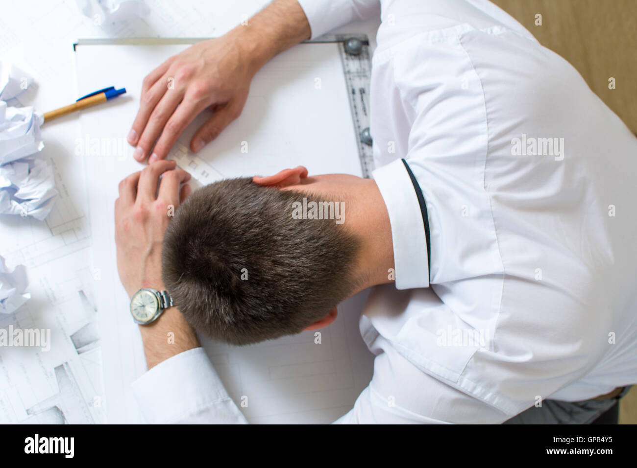 Tired architect sleeping on top of his project Stock Photo - Alamy