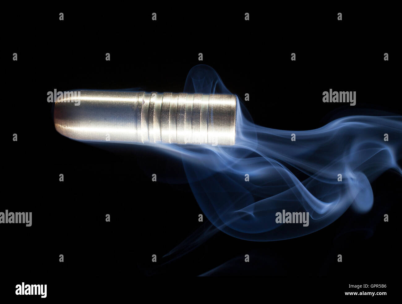 Bronze colored bullet with smoke on a black background Stock Photo - Alamy