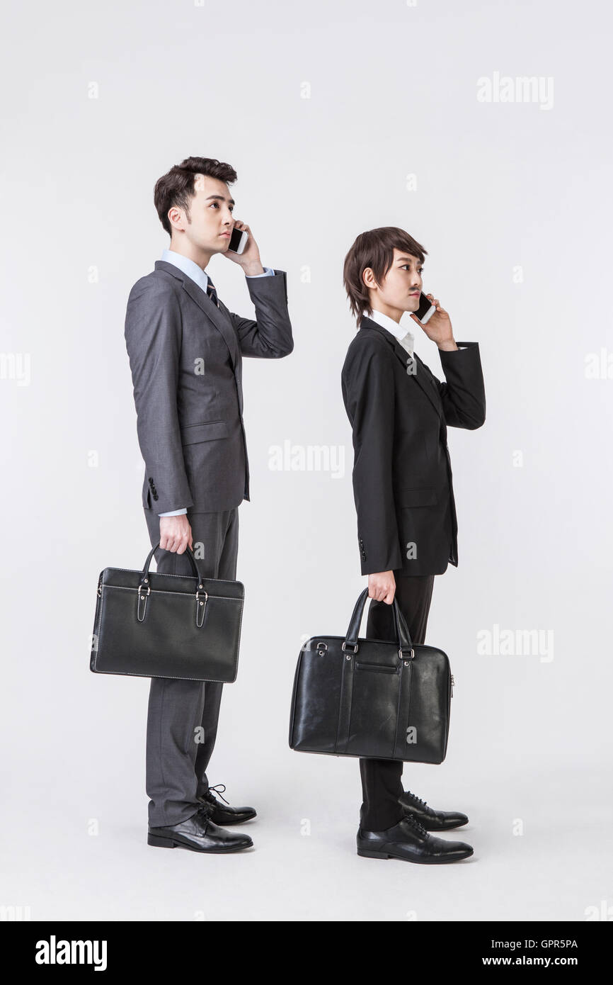 Business people standing talking on cellphones Stock Photo - Alamy