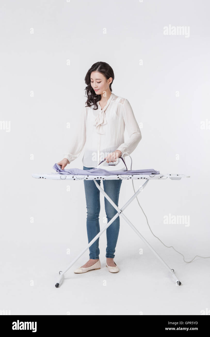 Young woman ironing Stock Photo - Alamy